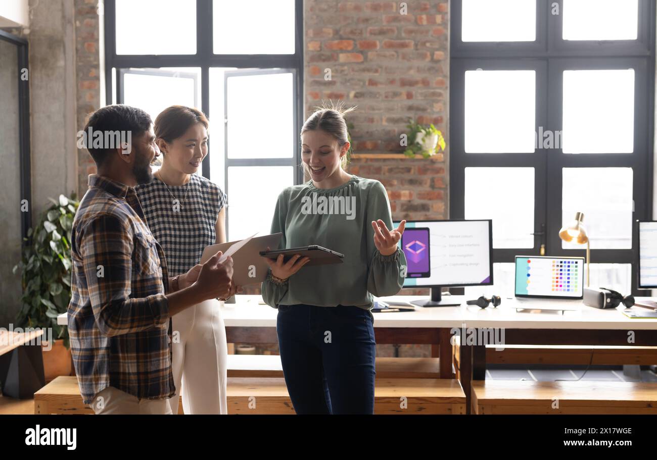 A diverse team discussing app design in a bright, modern business ...