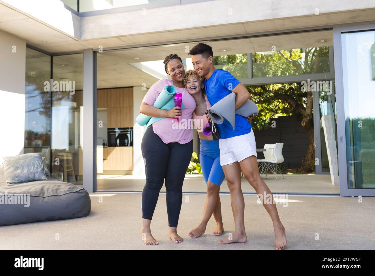 Group of friends laughing outside modern home Stock Photo - Alamy
