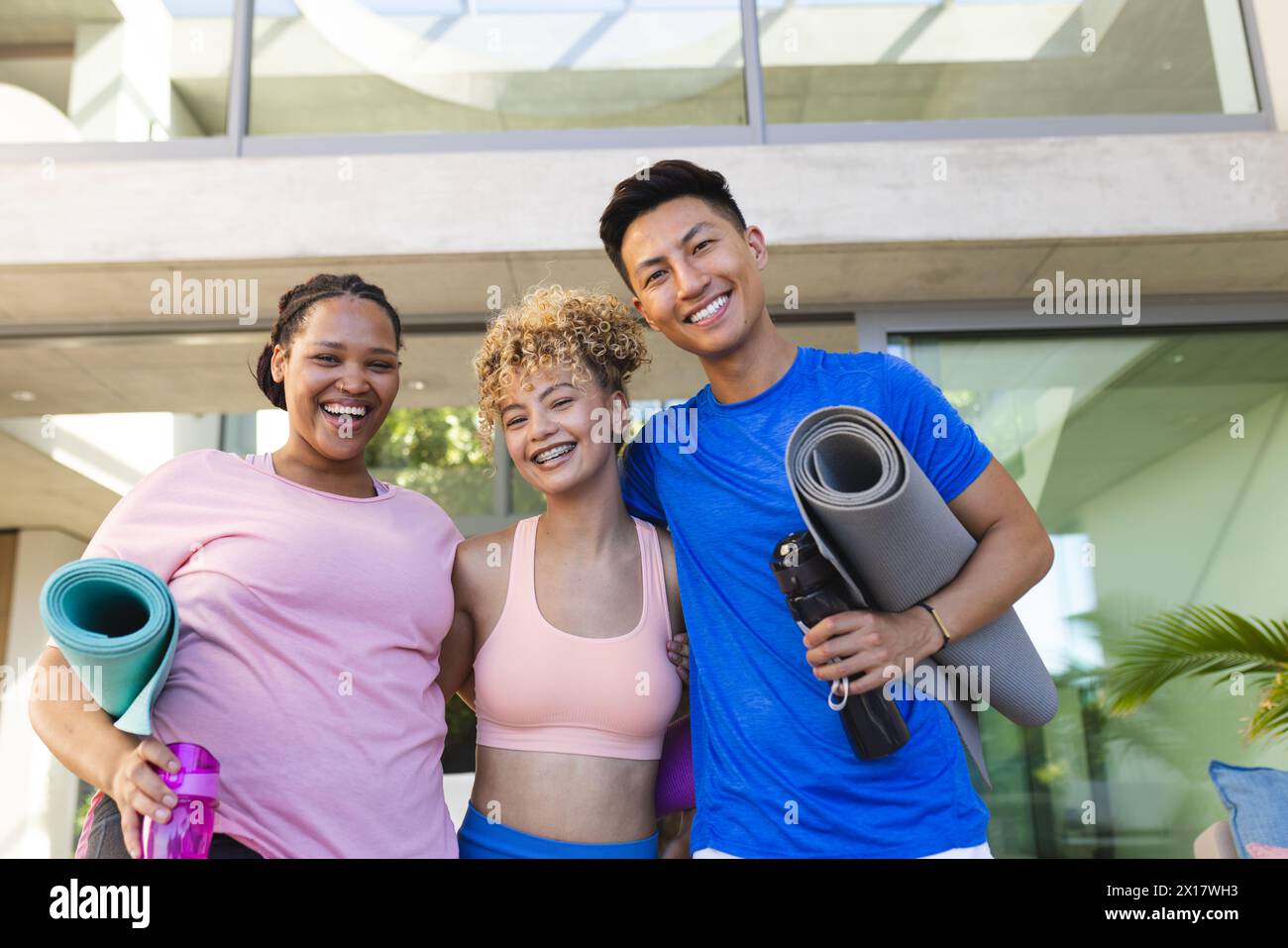 Diverse group of friends holding yoga mats, smiling outside Stock Photo ...