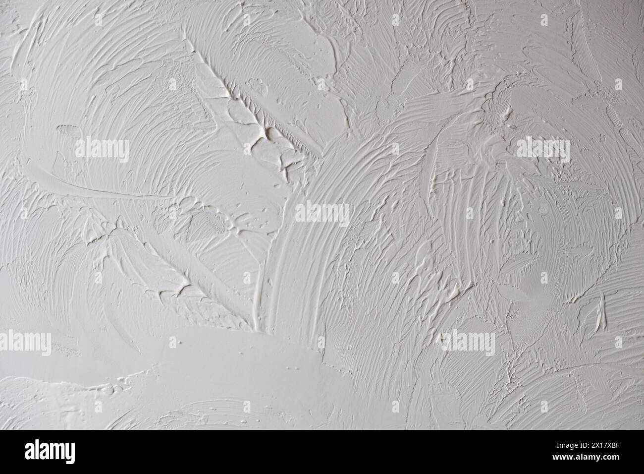Applying decorative putty. White abstract texture of surface covered ...
