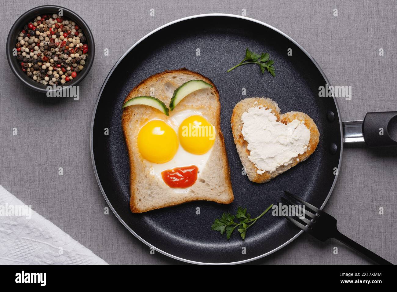 Heart shaped fried eggs with toast in frying pan on grey table, top view Stock Photo - Alamy