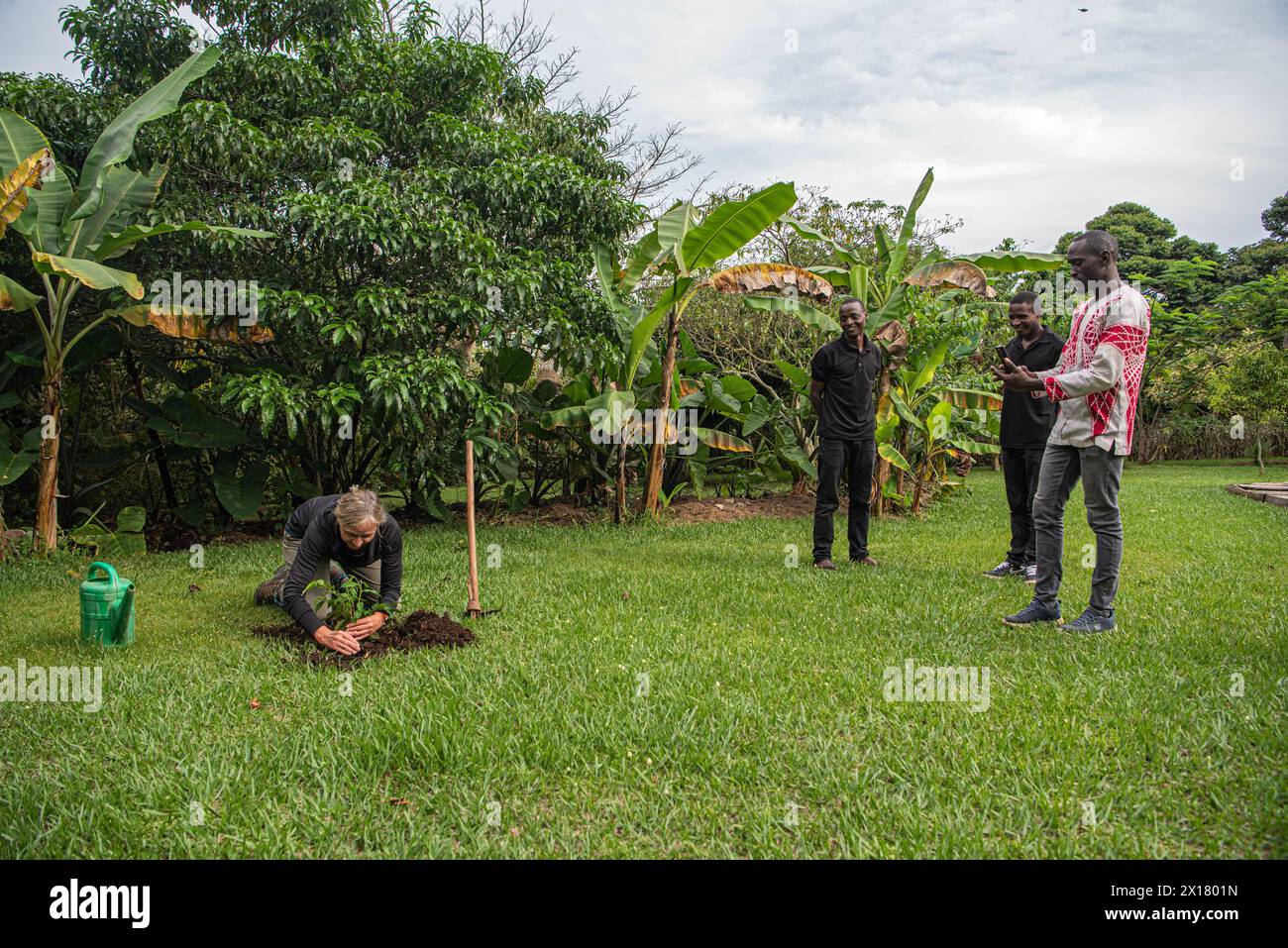 A woman, along with hotel staff, engages in eco-friendly practices by ...