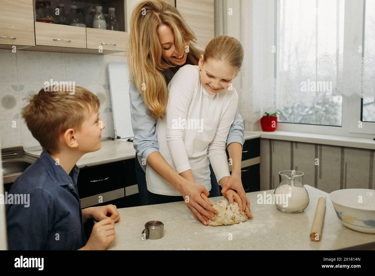 A woman and two children are actively engaged in the process of ...