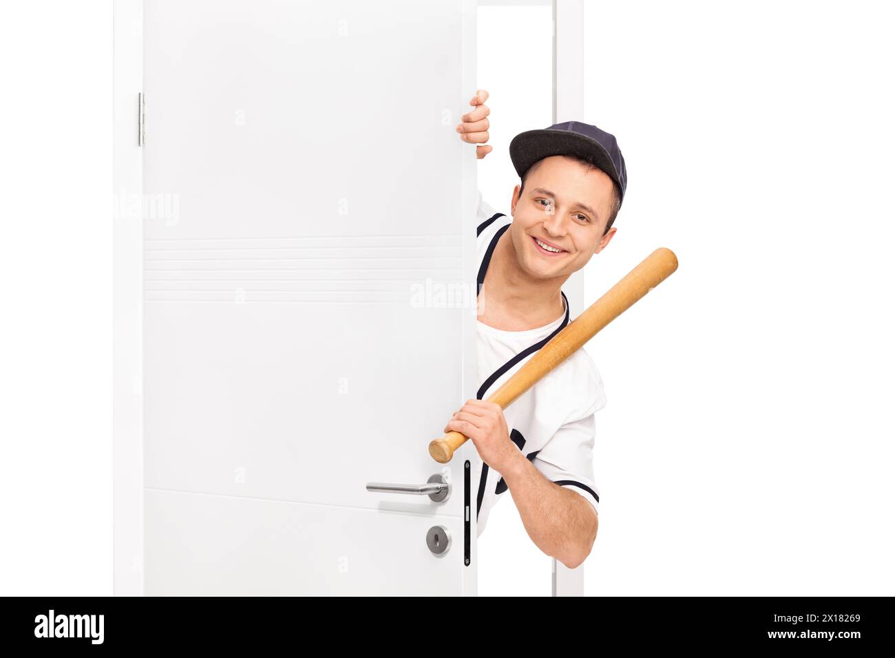 Guy holding baseball bat behind a door isolated on white background ...
