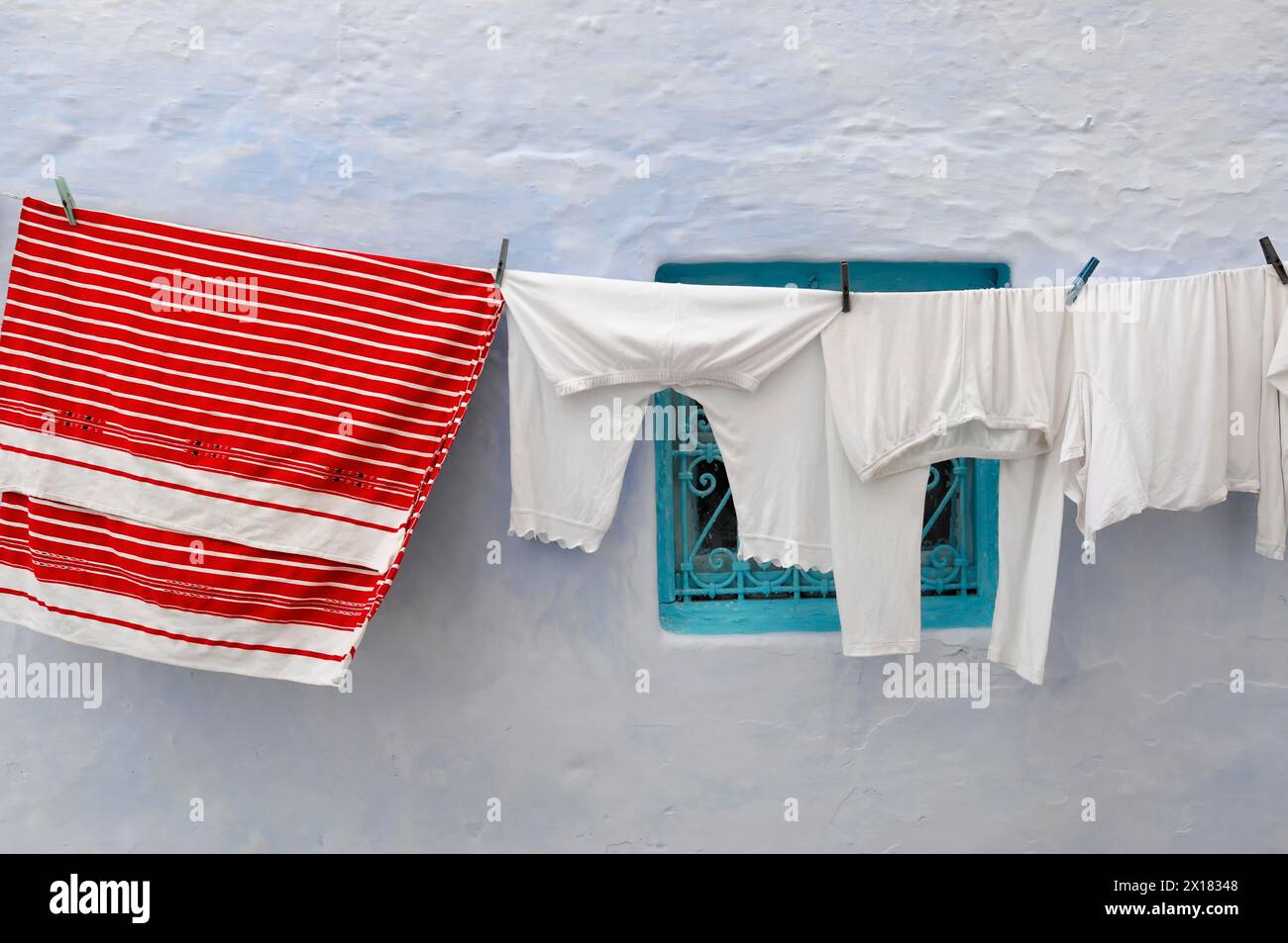 Chefchaouen, Hanging laundry in front of a blue and white Moroccan wall ...