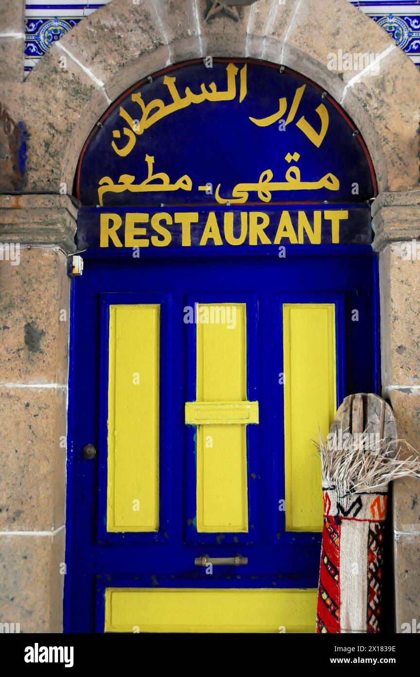 Essaouira, Blue and yellow door to a restaurant with Arabic and Latin ...