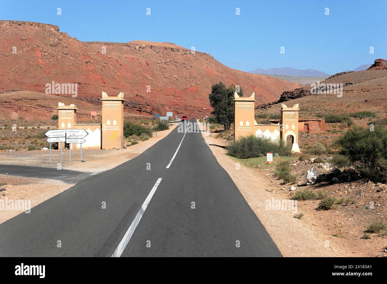 Ait Benhaddou, Empty highway in the desert, bordered by archways and ...