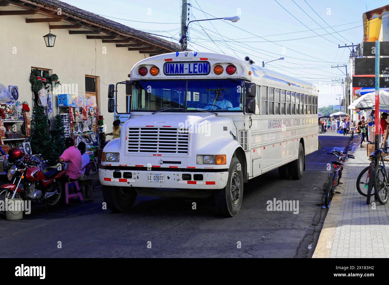 Leon Nicaragua, Colourful bus on a busy street next to market stalls ...