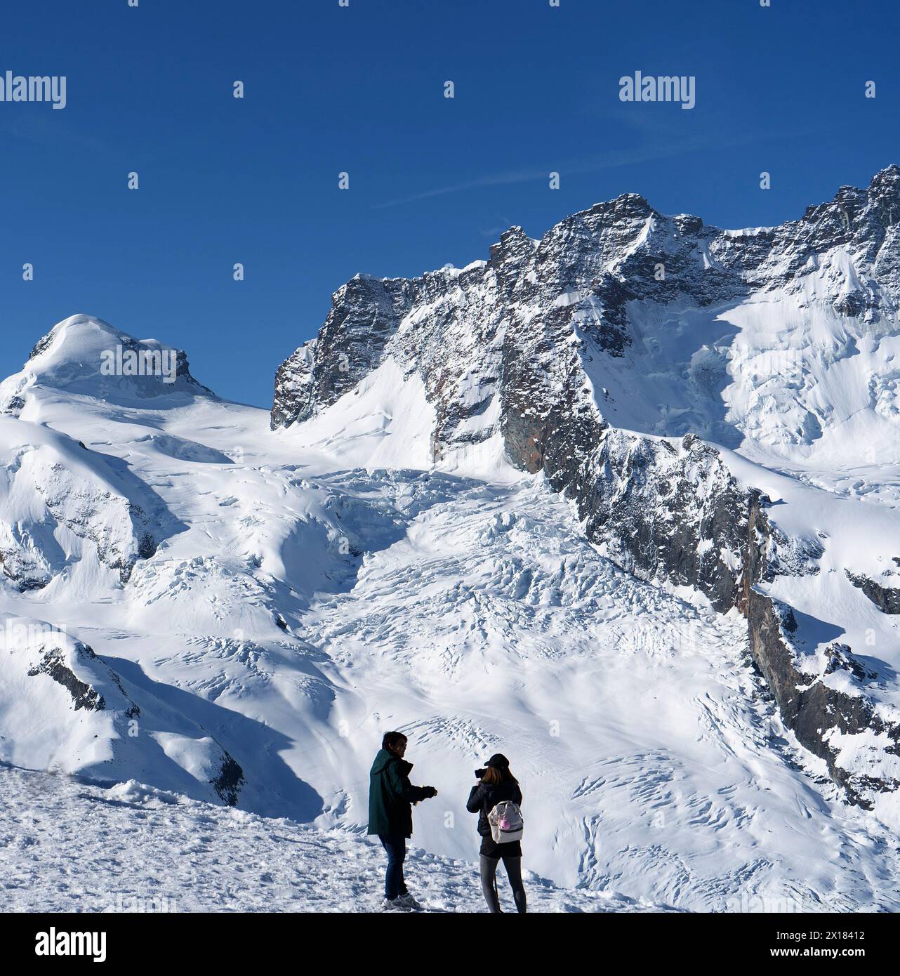 Tourist couple viewing the Gorner Glacier in the Pennine Alps ...
