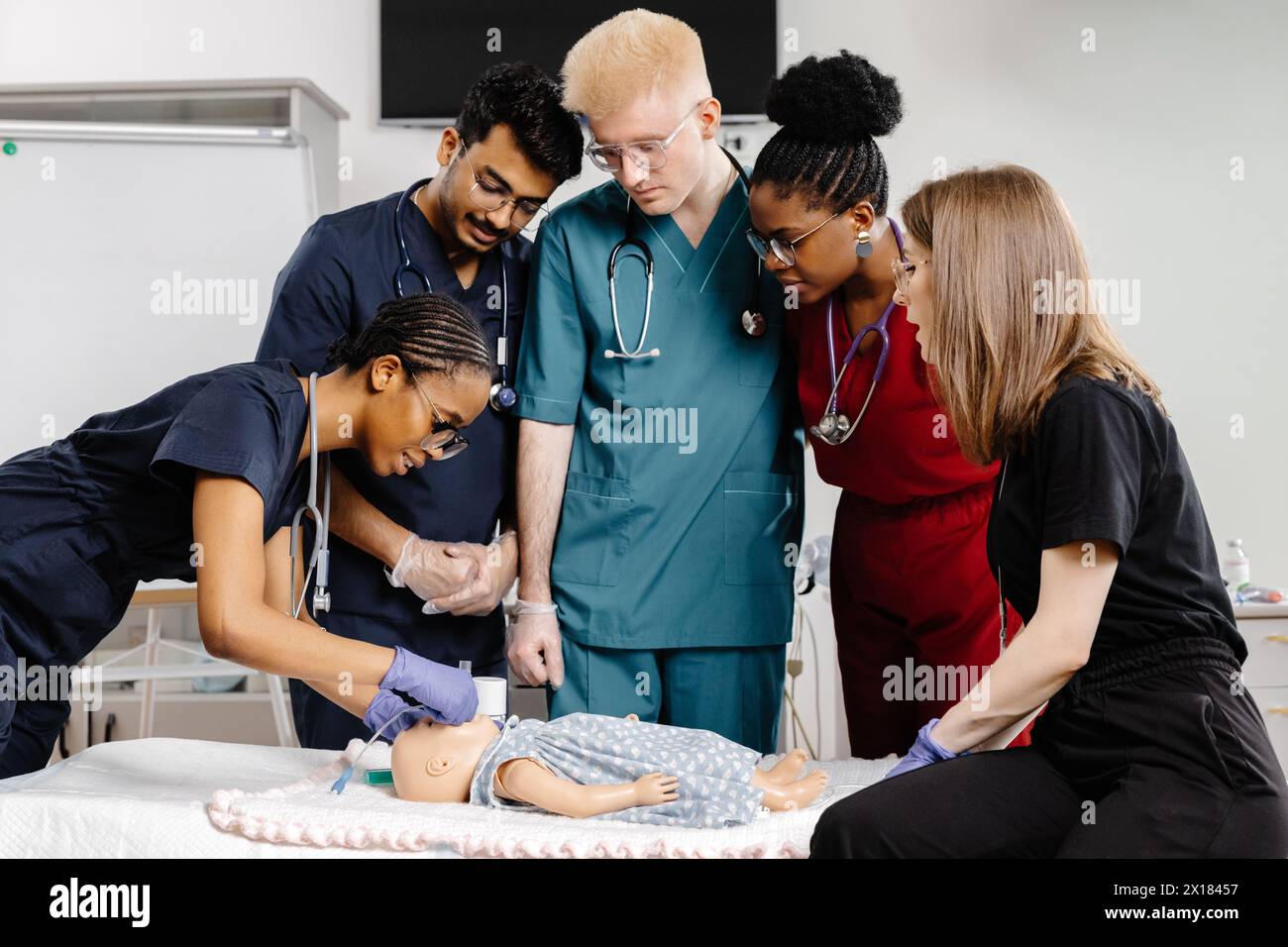 A group of doctors in professional attire standing attentively around a ...