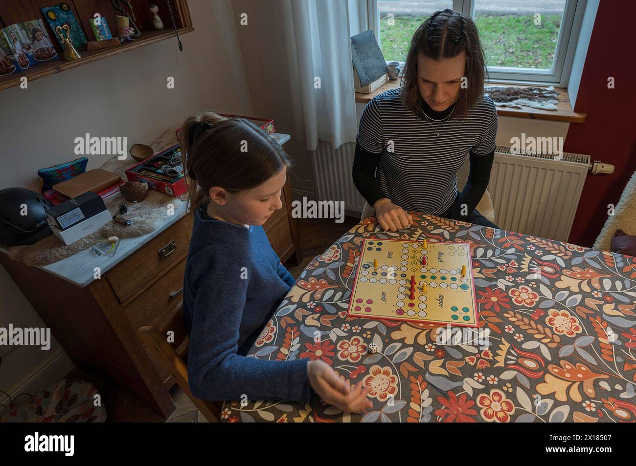 Two sisters playing the parlour game Mensch Aergere Dich nicht ...