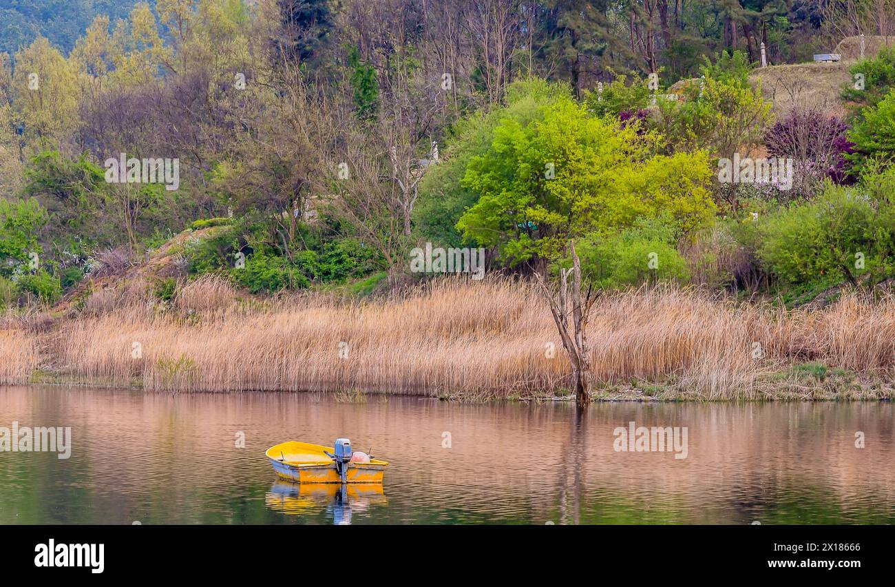 Small yellow metal fishing boat with small engine mount floating ...