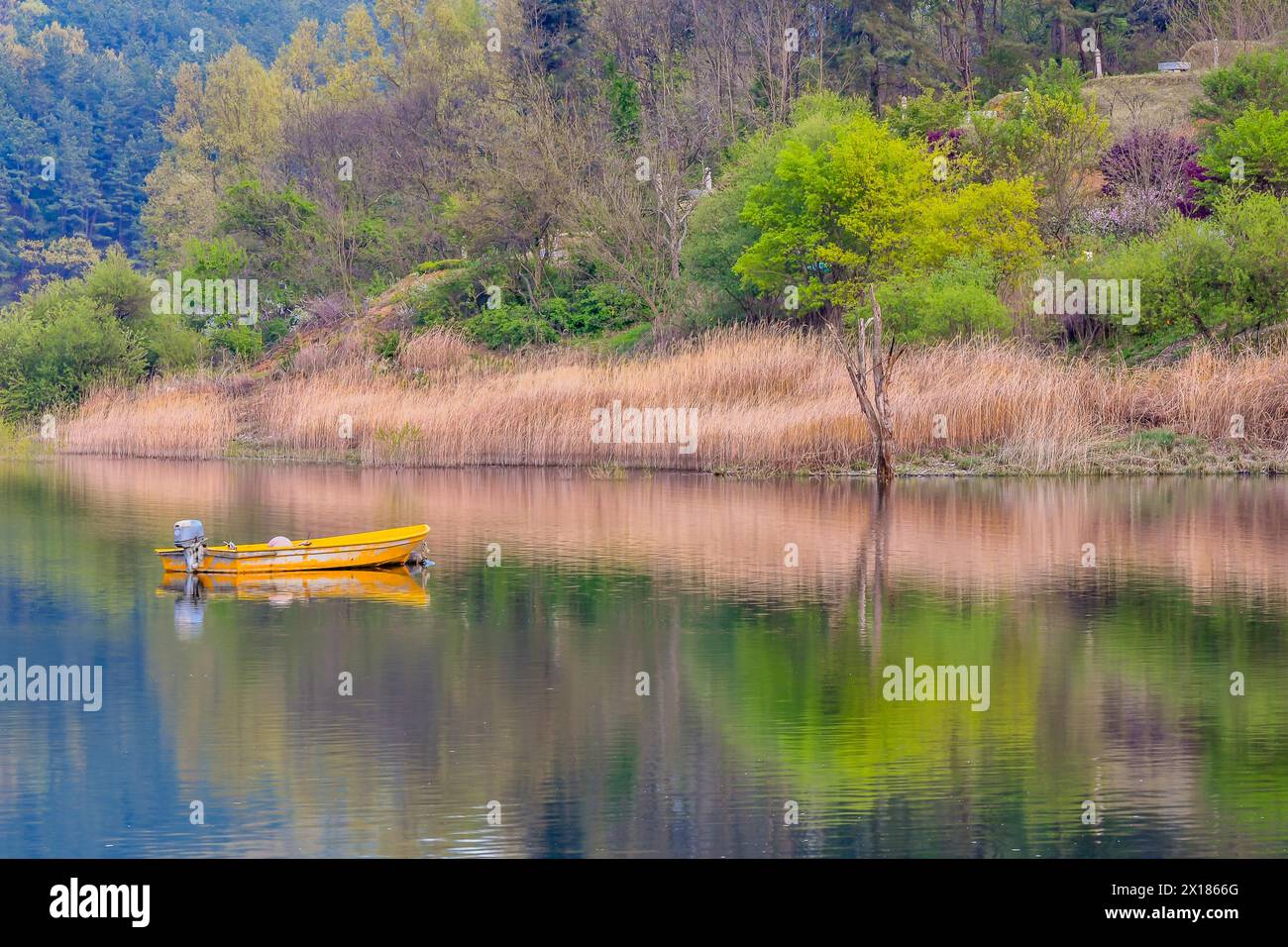 Small yellow metal fishing boat with small engine mount floating ...
