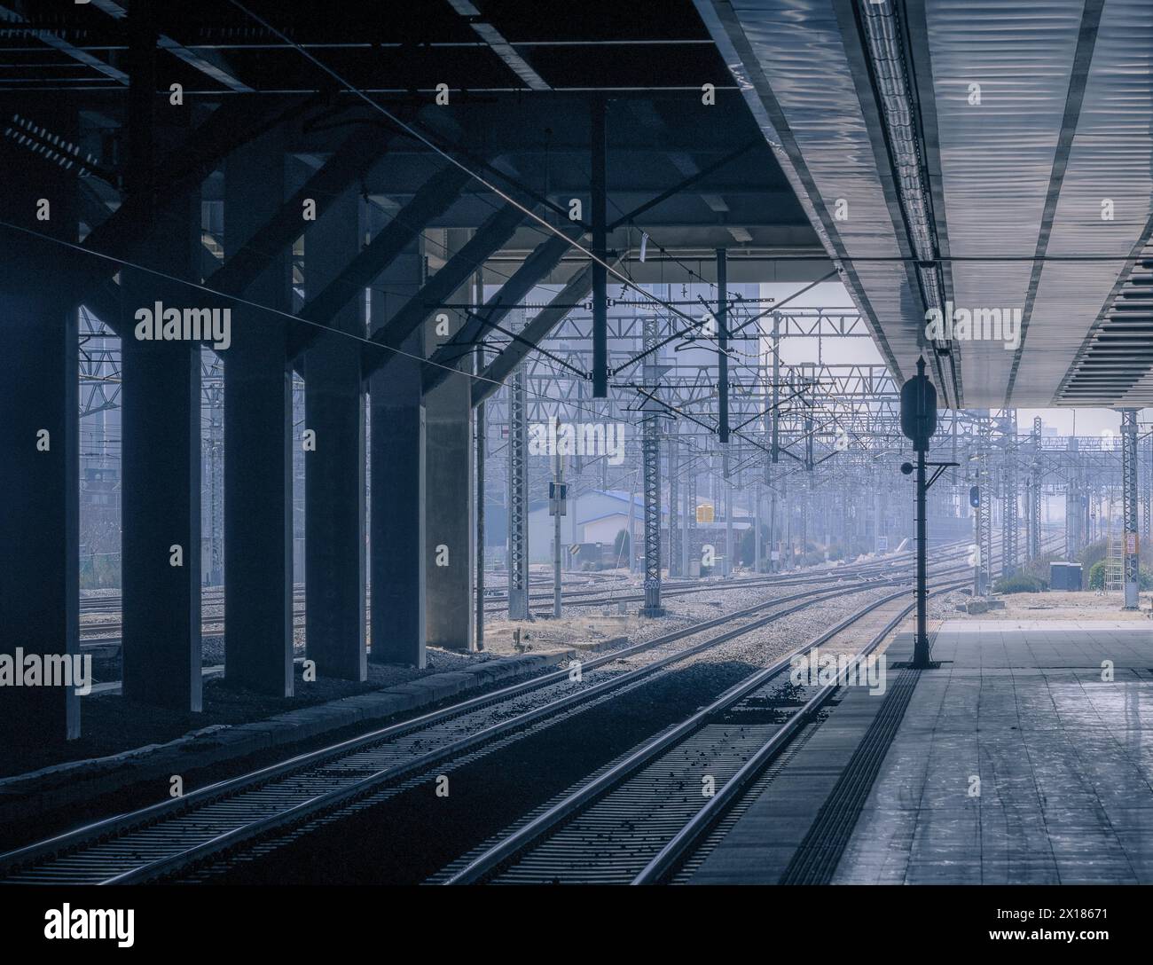 Subway platform with tracks leading into the distance under electrical ...