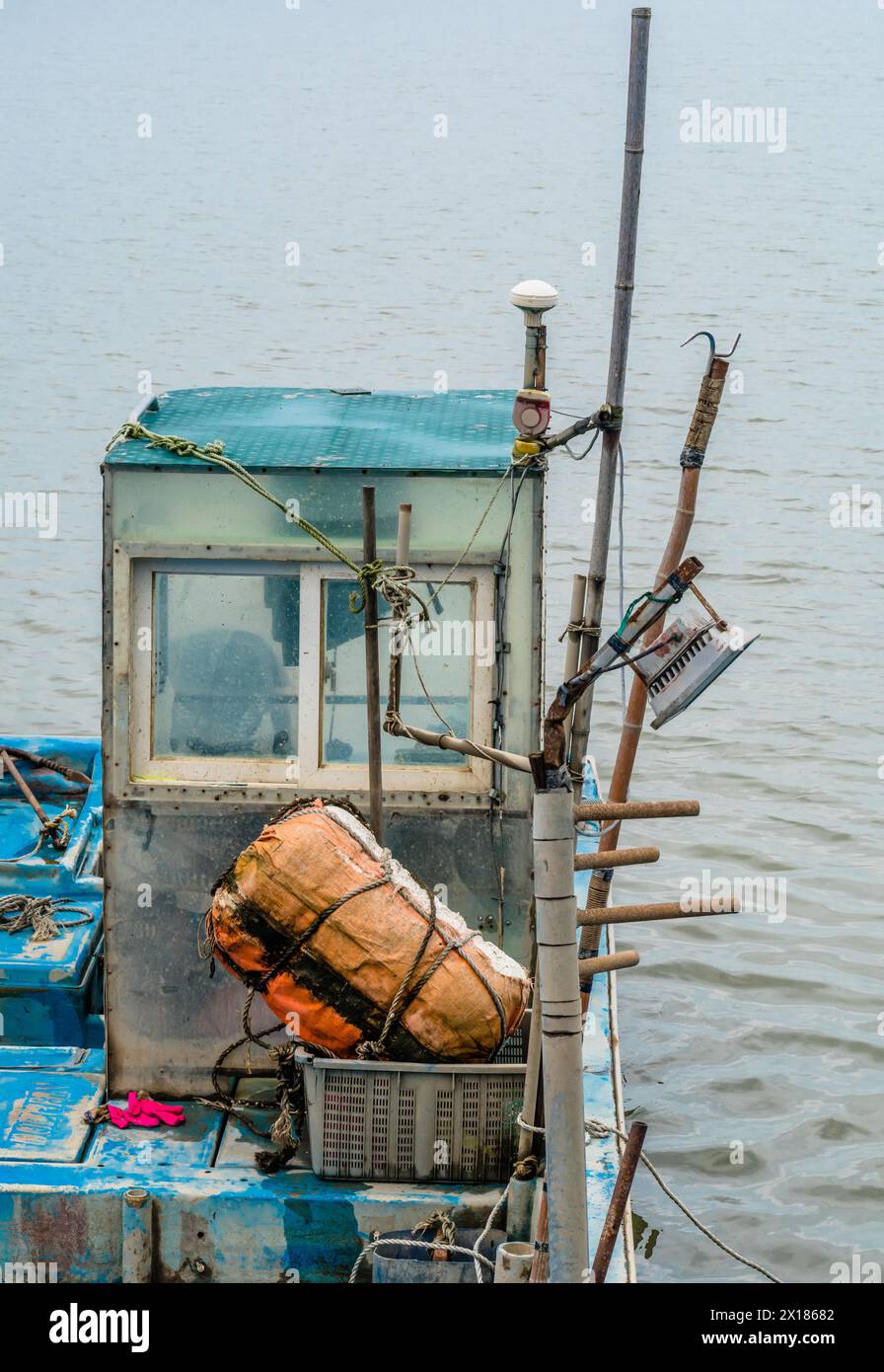 The cluttered cabin and deck of a fishing boat with nets and gear ...
