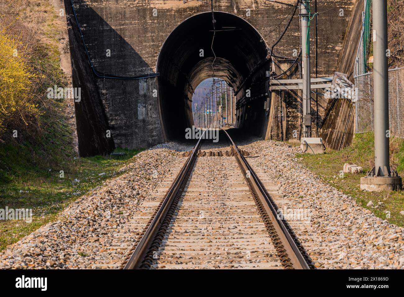 Closeup of a train tunnel cut through the side of a small mountain with ...
