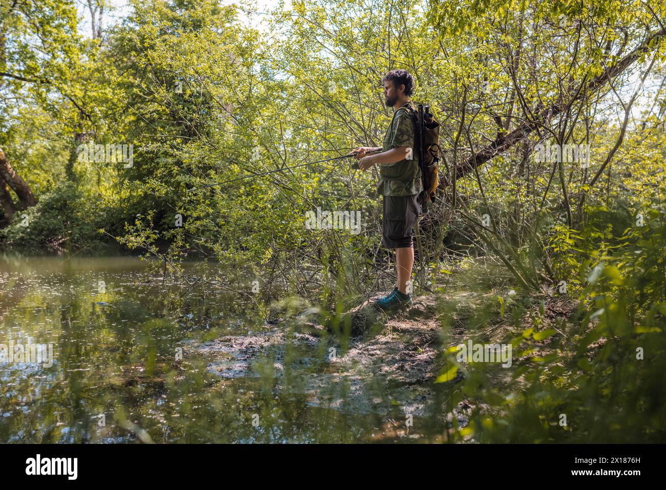 Recreational fisherman at river bank trying to catch a fish. Angler ...