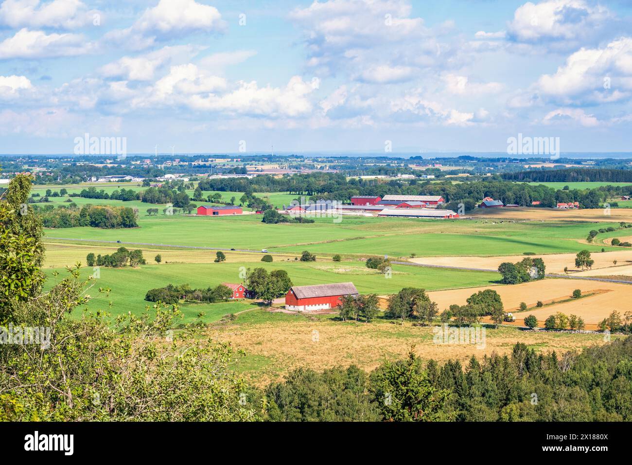 View at a country landscape in a rural area with farms and field in a ...