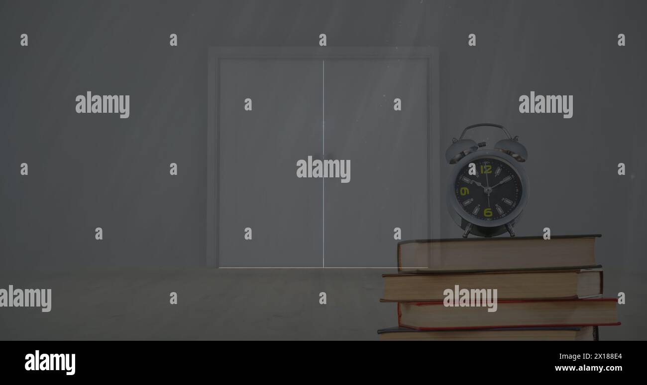 Image of alarm clock on books over table and light streaming through ...