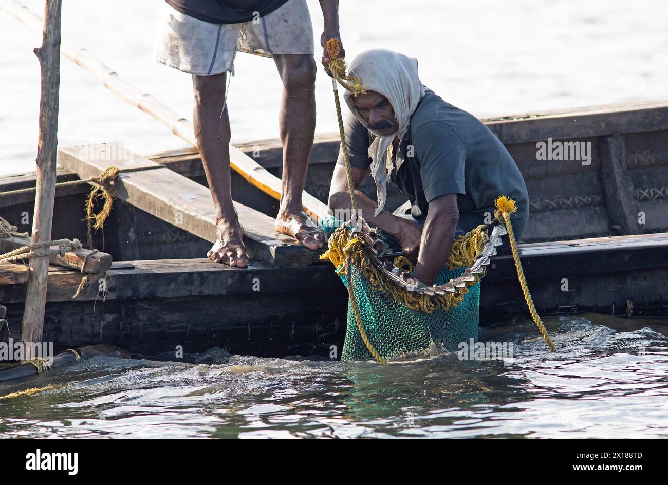 Mussel fisherman emptying his net on the Vembanad Lake, canal system of ...