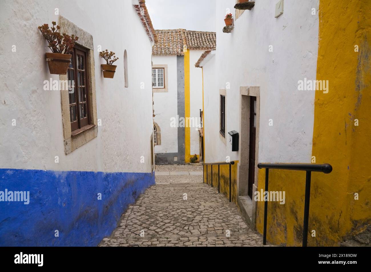Old street with mosaic style paving stone stairs and white roughcast ...