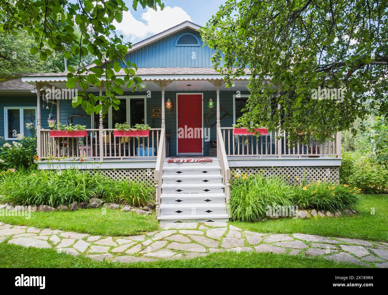 Blue and tan country cottage style residential home facade with veranda ...