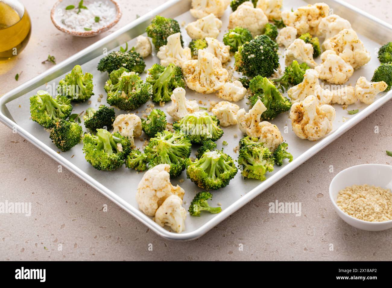 Broccoli and cauliflower florets on a sheet pan ready to be roasted ...
