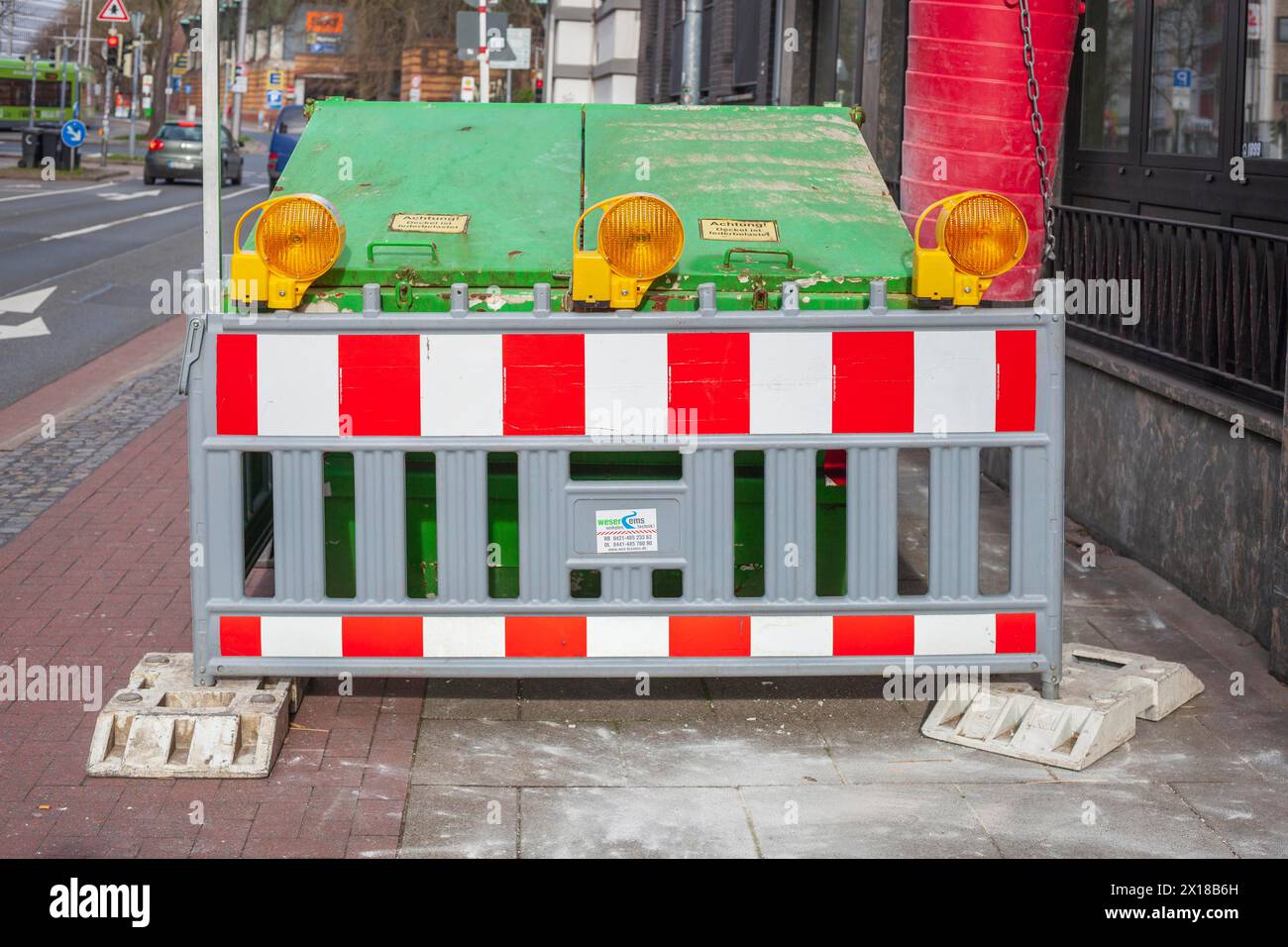 Construction site with barrier and waste container or skip for building ...
