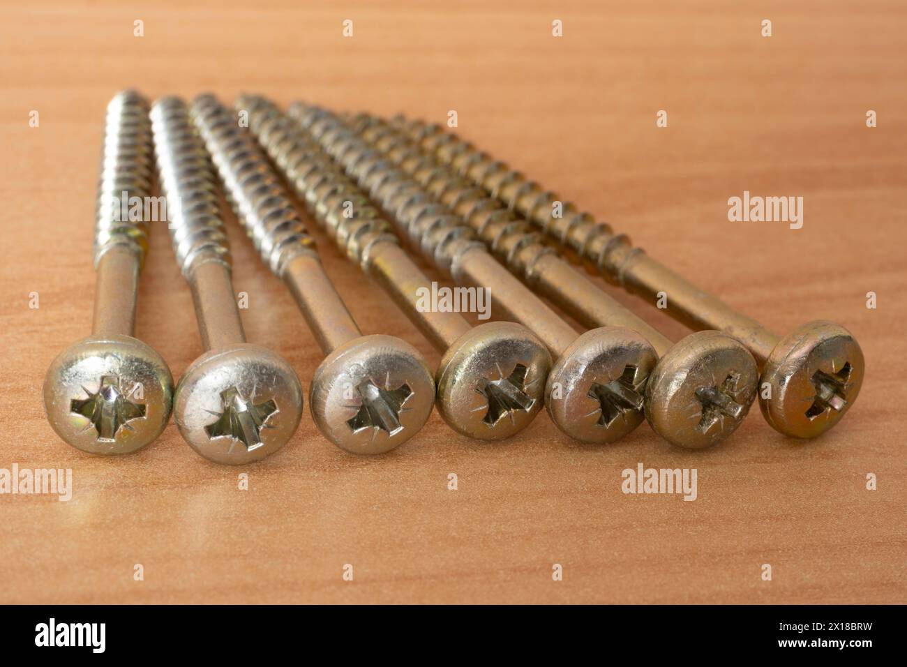 Phillips screws on wooden background, wood screws Stock Photo - Alamy