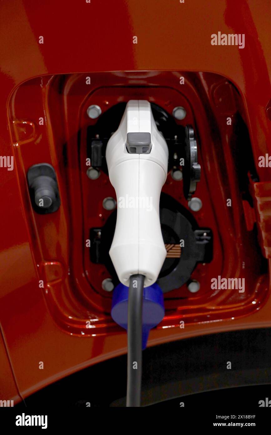 Close-up photo of a connector for charging connected to a red electric ...