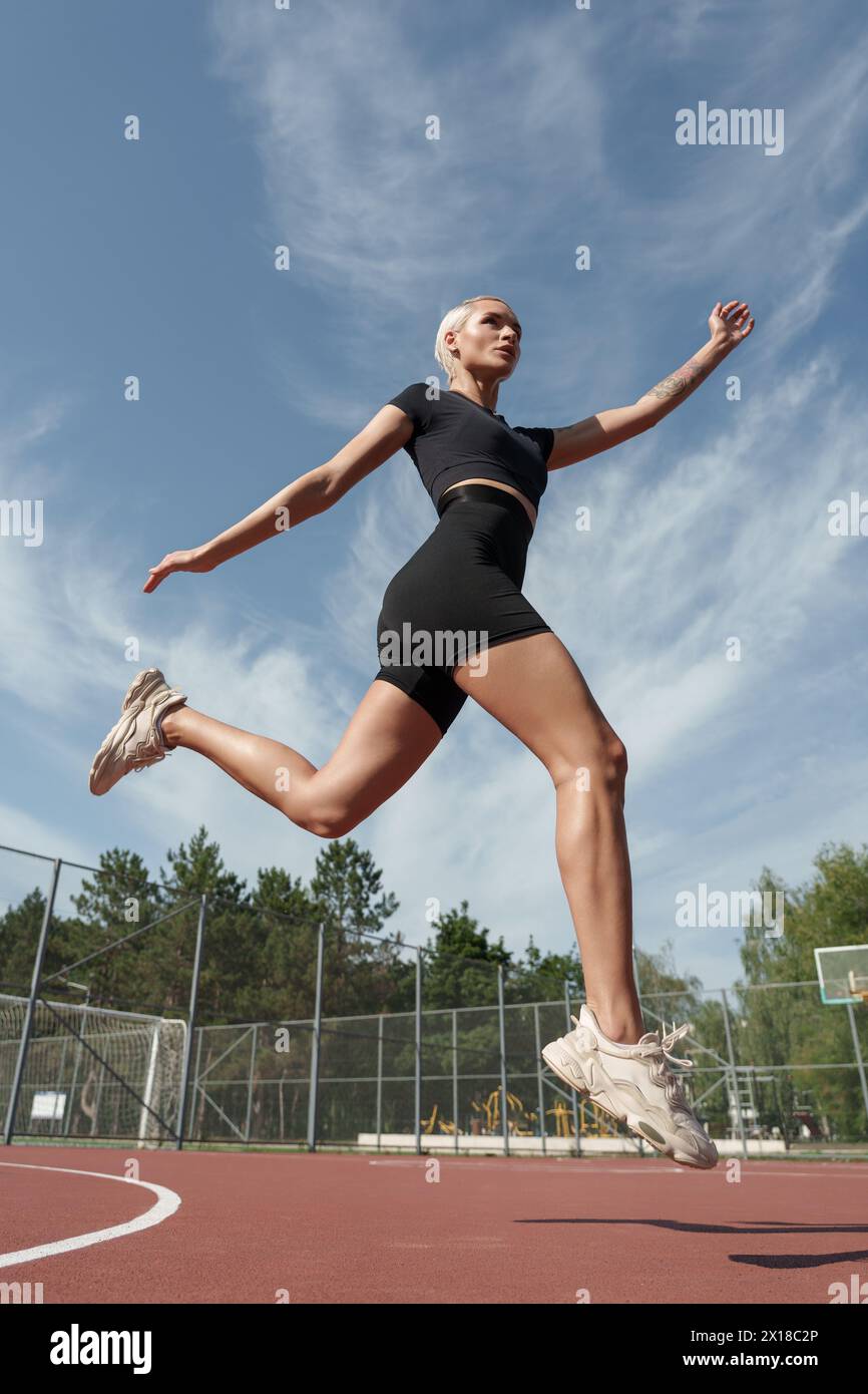 Athletic woman sprinting on a running track outdoors Stock Photo - Alamy