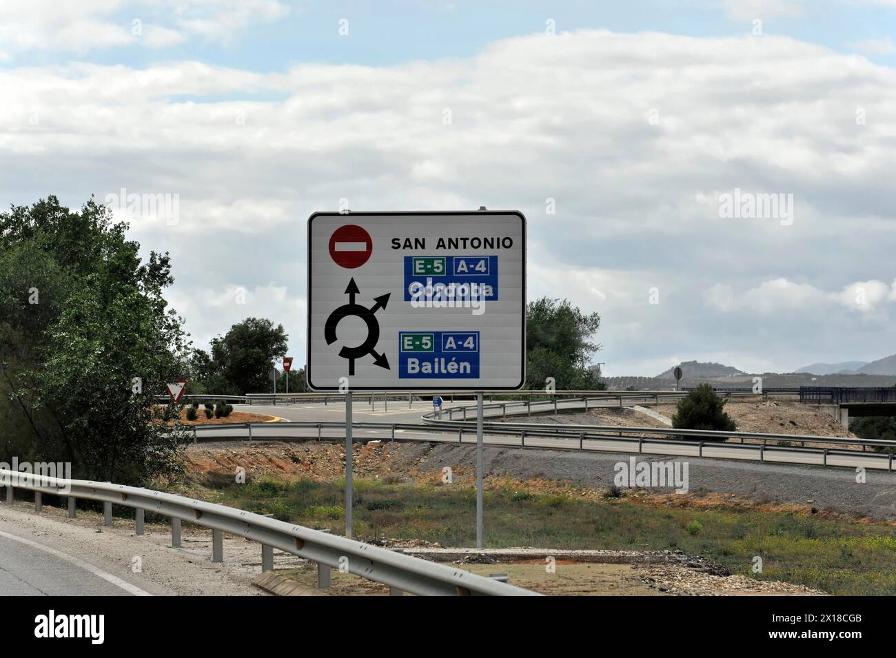A roadside sign points the way to various destinations at an empty ...