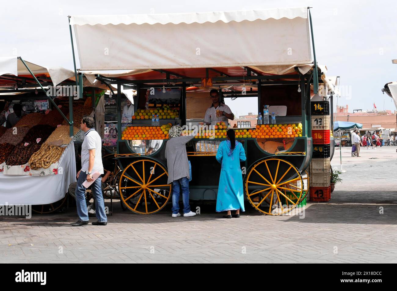 Marrakech, A busy market stall with a vendor, customers and various ...