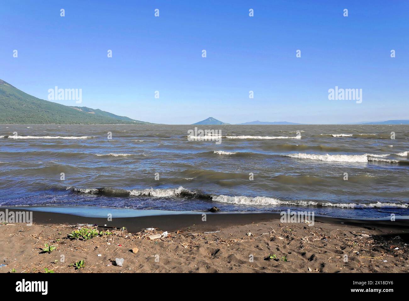 Lake Managua, Leon, Nicaragua, waves breaking on a rocky shore with a ...