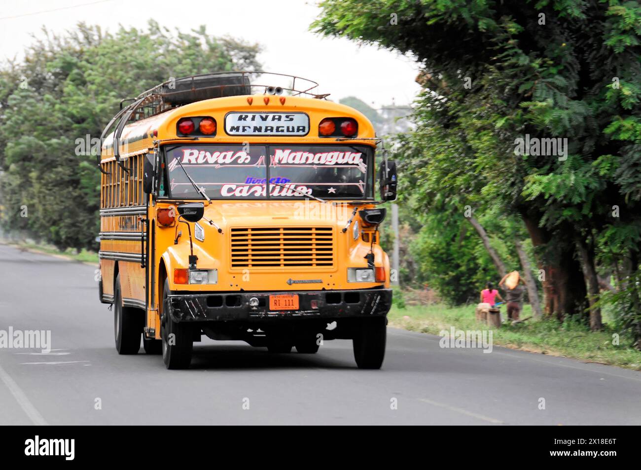 On the road near Rivas, Colourful bus driving on a road, typical means ...