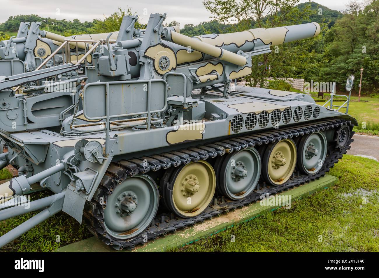 A camouflaged military artillery tank displayed outdoors at a museum ...