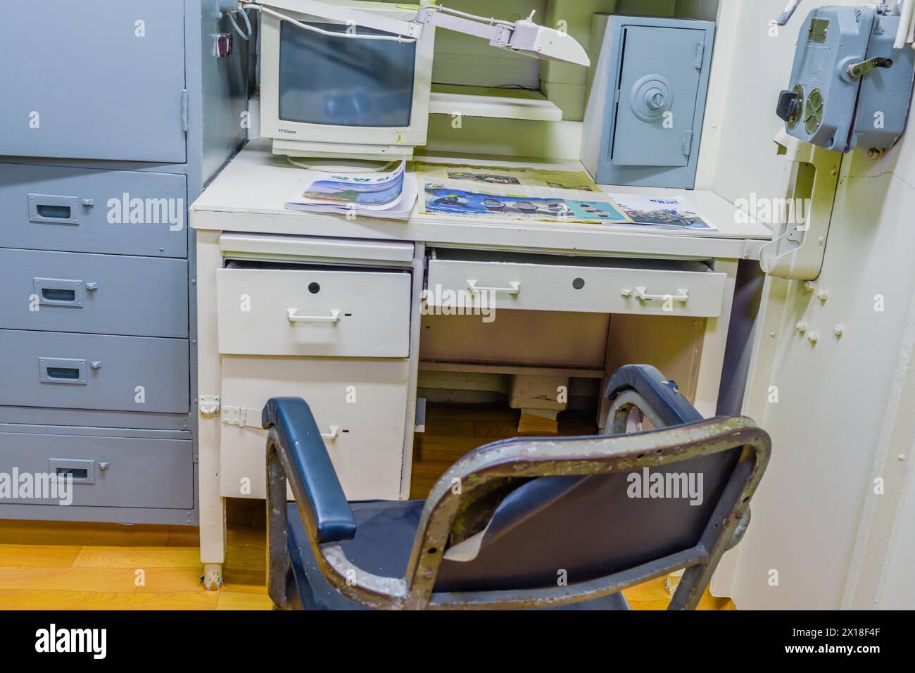 Interior of officer's cabin with desk chair computer and magazines ...