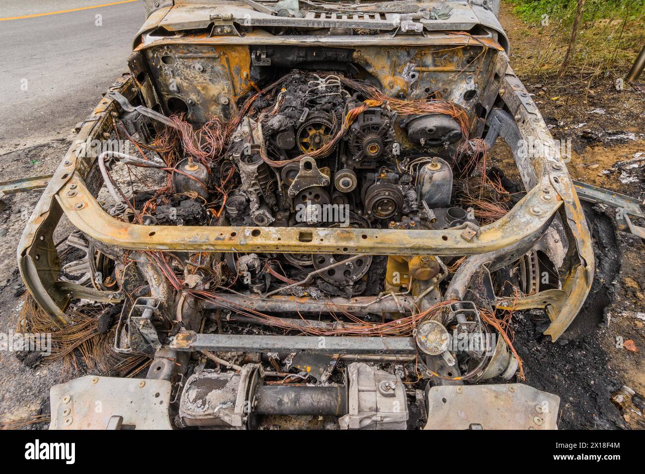 Front view of engine compartment of automobile abandoned on side of ...