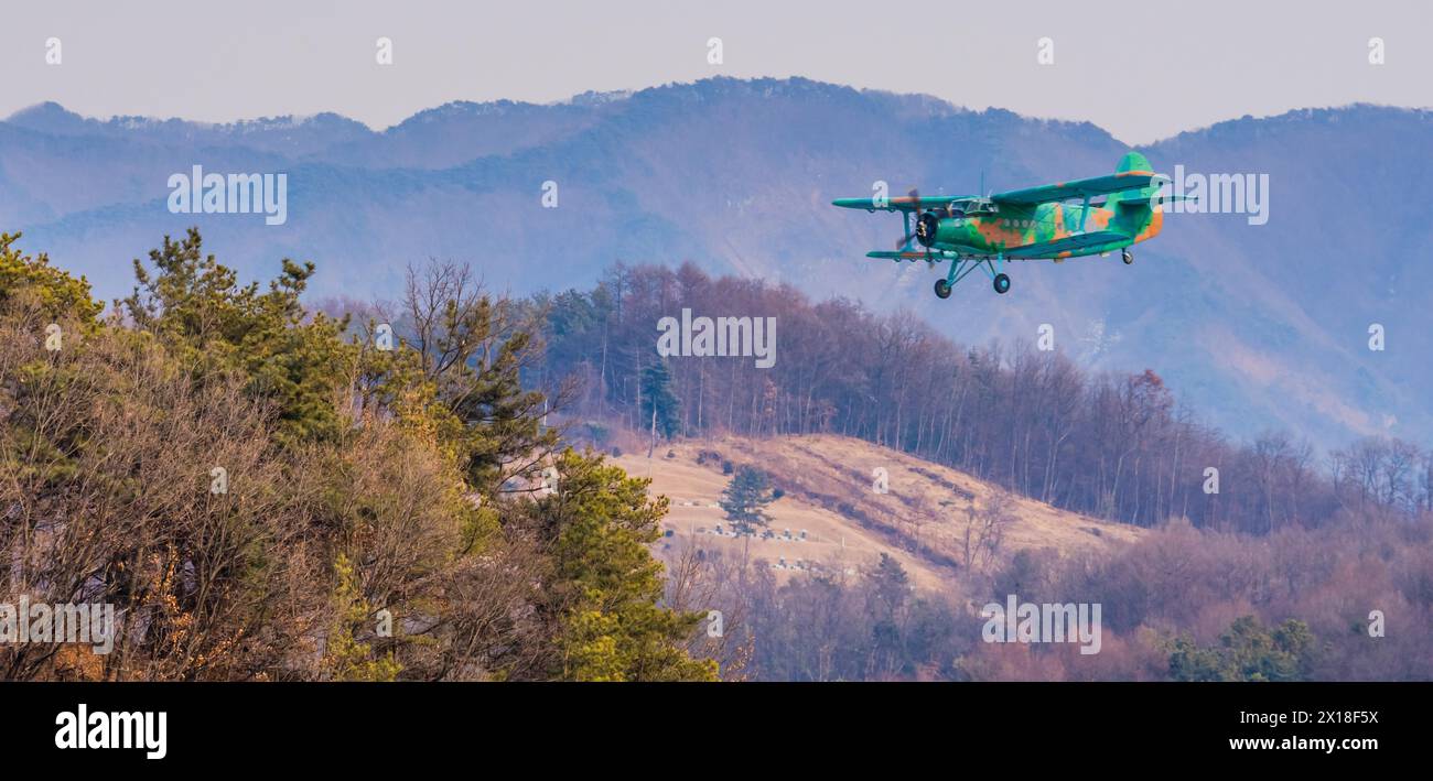 ROK military biplane training aircraft flying over mountainous region ...