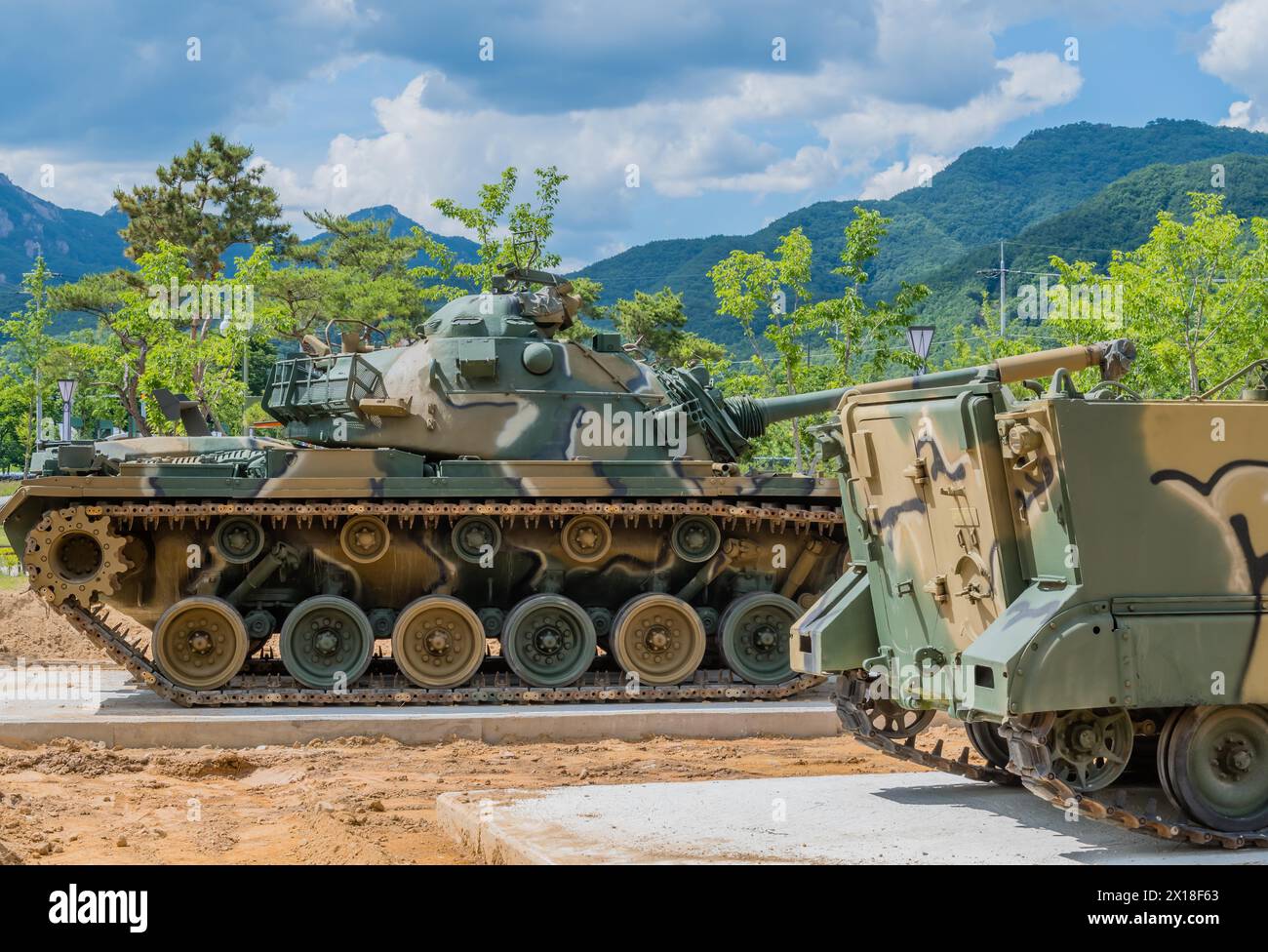 Side view of camouflaged tank used in Korean war behind armored landing ...