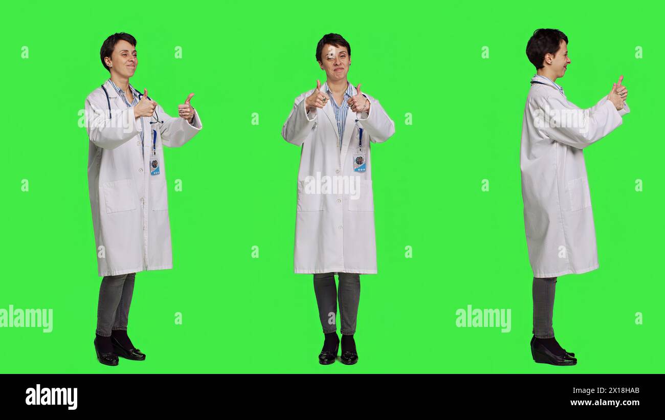 Cheerful medic doing thumbs up symbol against greenscreen backdrop ...