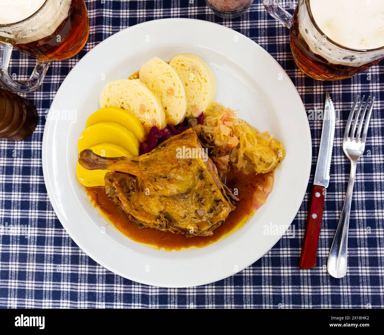 Roasted quarter duck with red and white cabbage, bread and potato ...