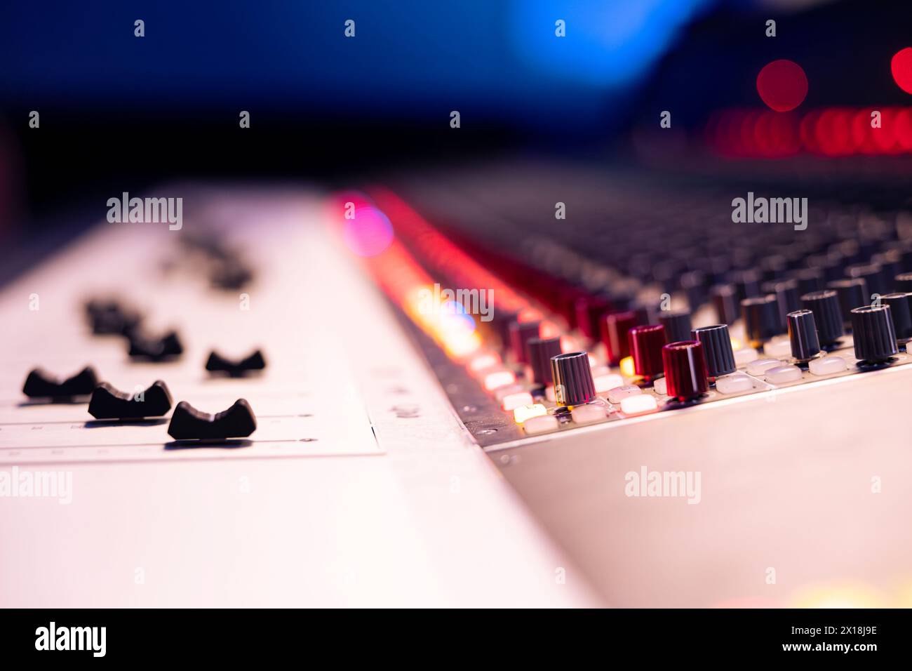 Control room desk with motorized faders and multiple knobs used in ...