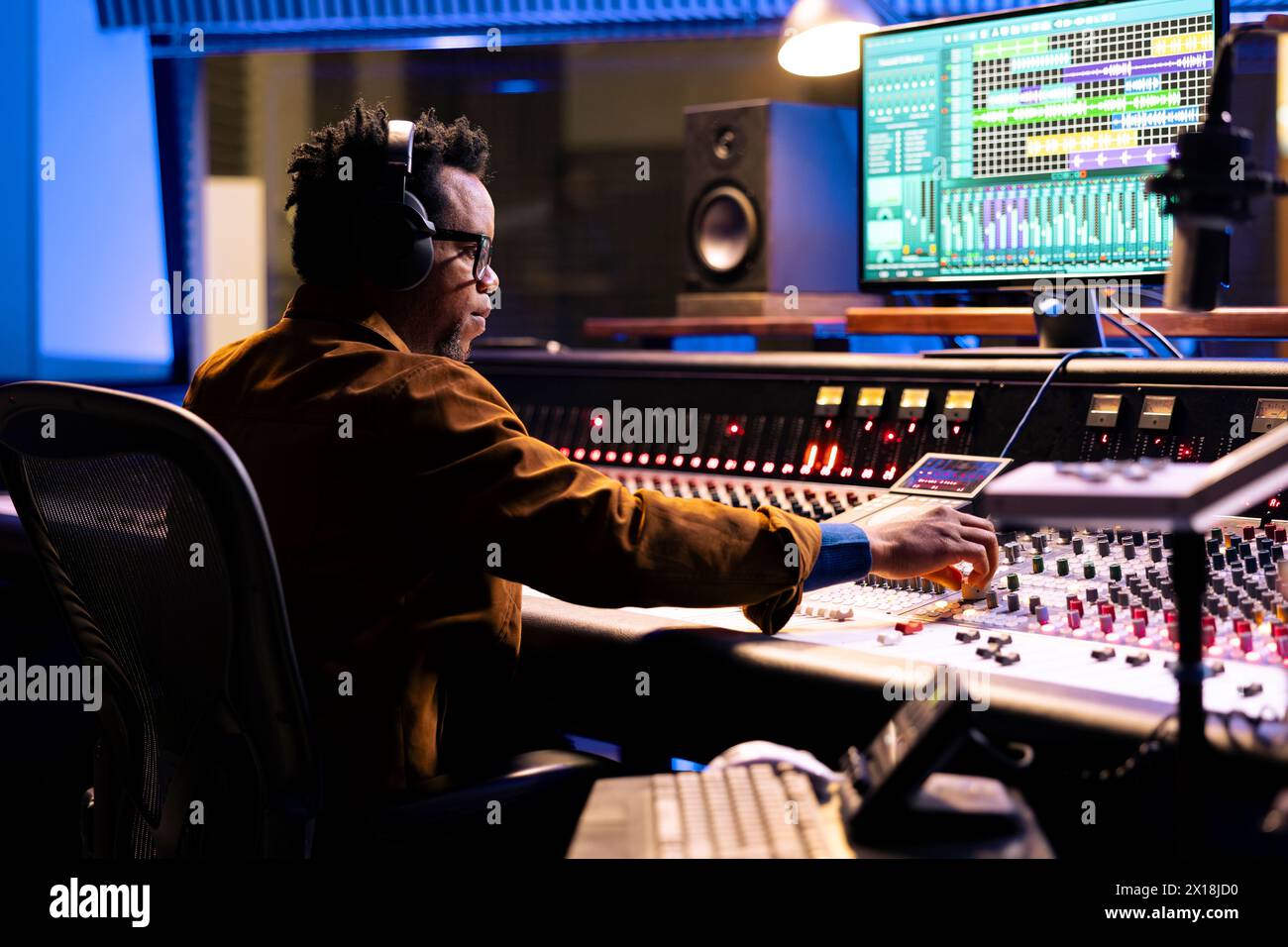 African american sound producer uses compressor and mixer in ...