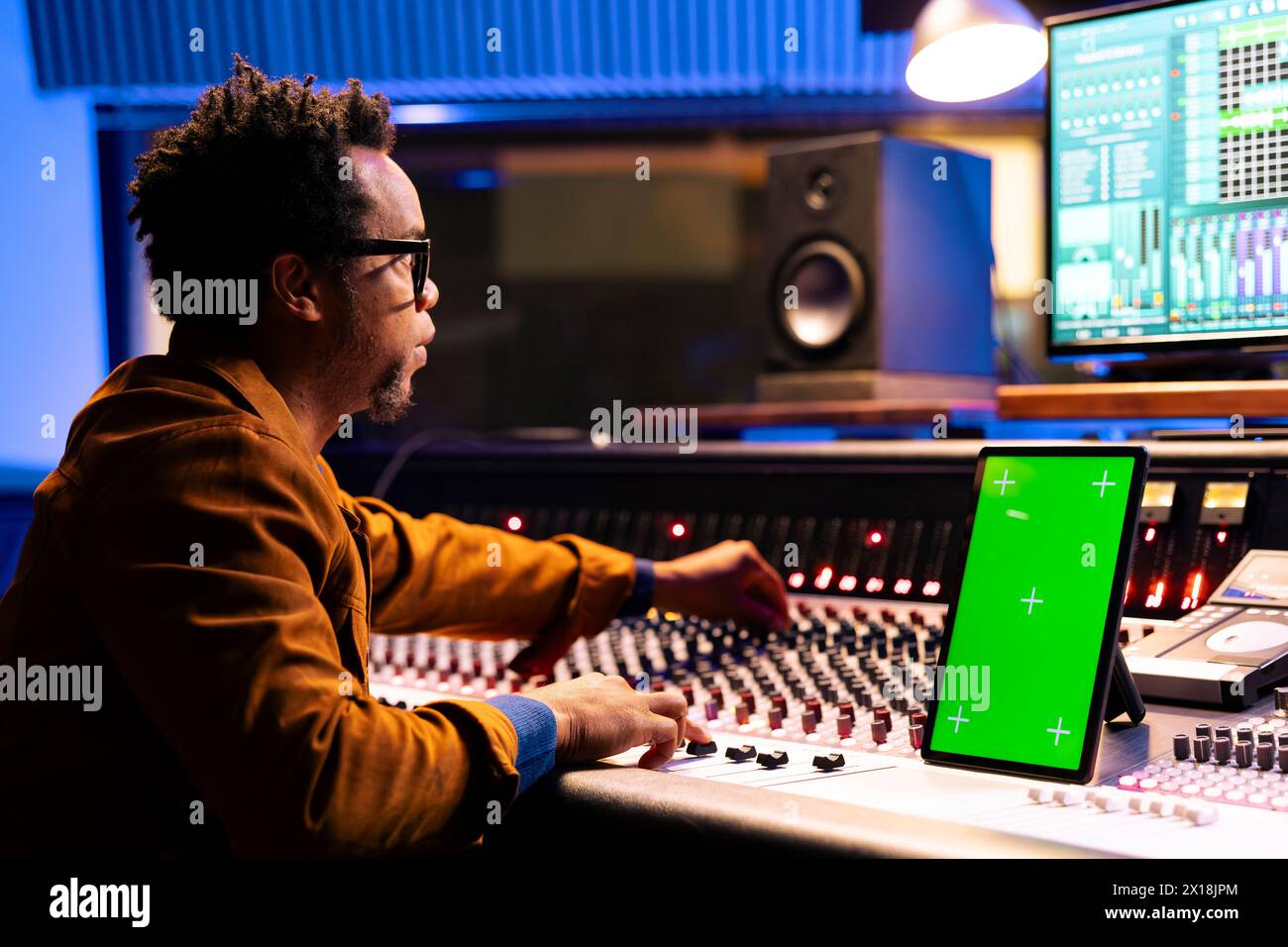 African american music producer recording and editing tracks in studio ...