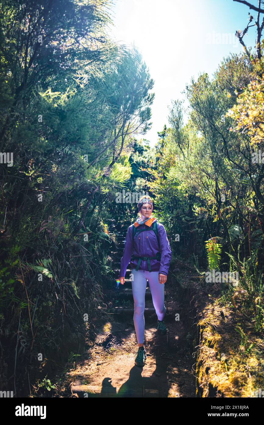 Description: Female tourist with backpack hiking down stairs on ...