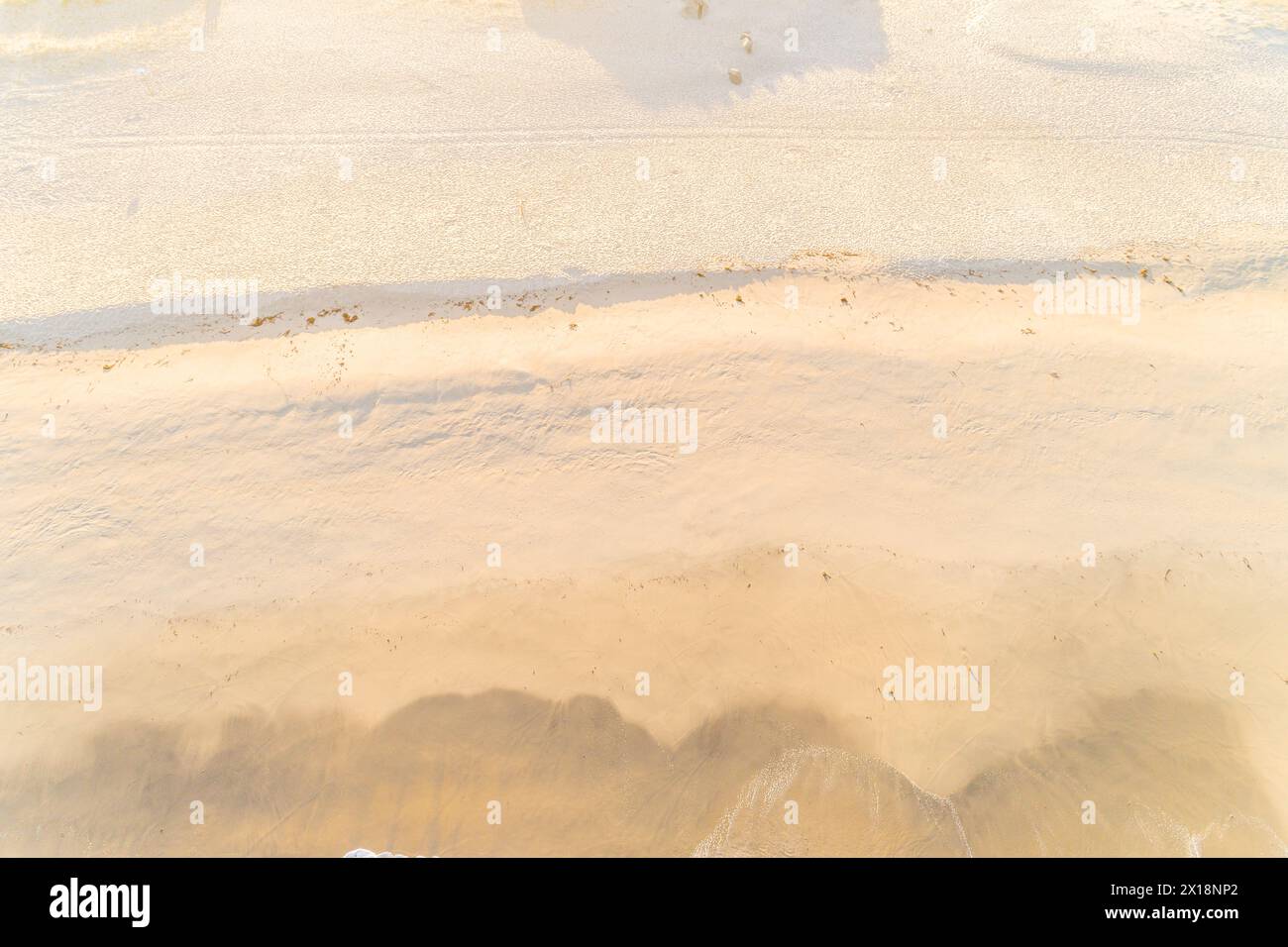sand on the shore of a beach at sunrise at low tide aerial view with ...