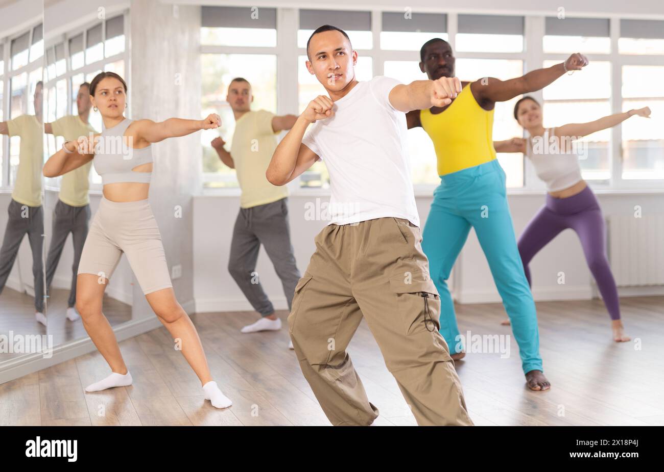 Guy practices kicking and punching in process of self-defense at group ...