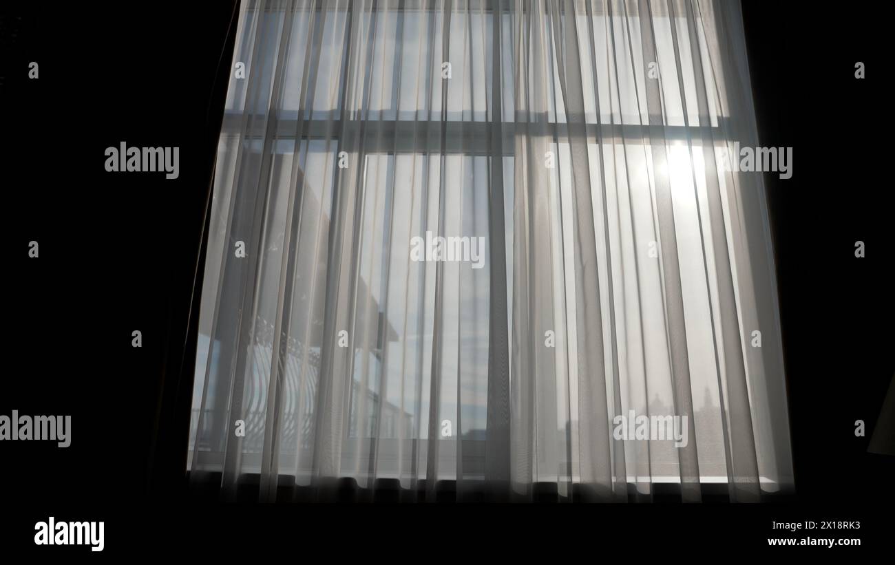 Abstract white fluttering curtain in an apartment. Window with white ...
