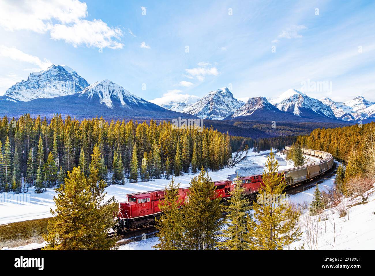 Red cargo train passing through Morant's curve in Bow Valley inside Banff National Park ...